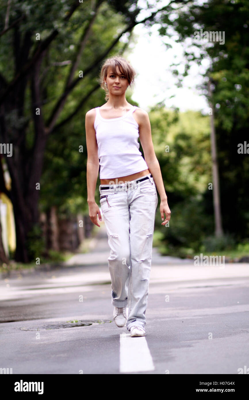Full length, walking woman in blue jeans Stock Photo - Alamy