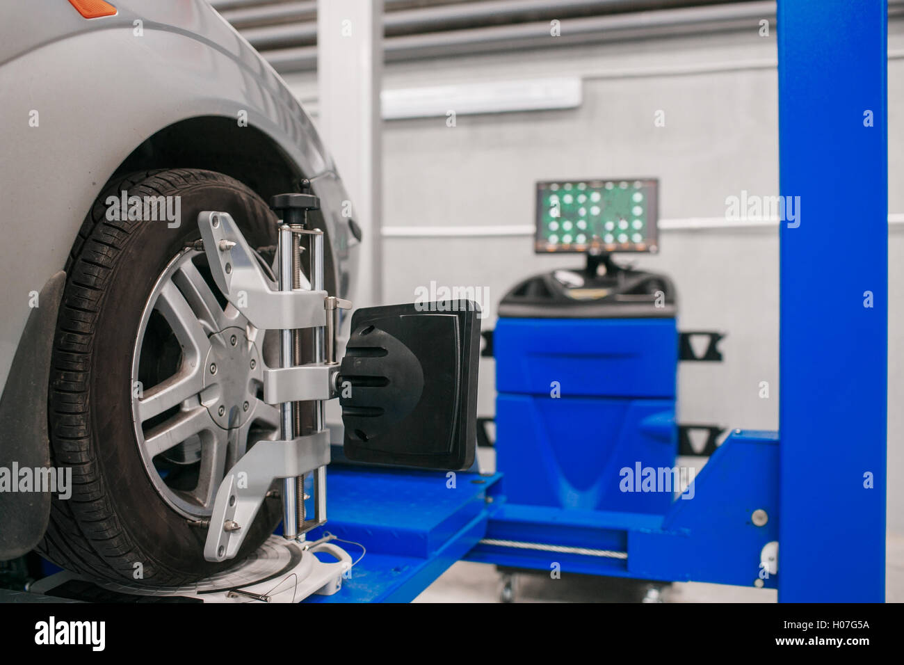 Car on stand with sensors on wheels for wheels alignment camber check ...