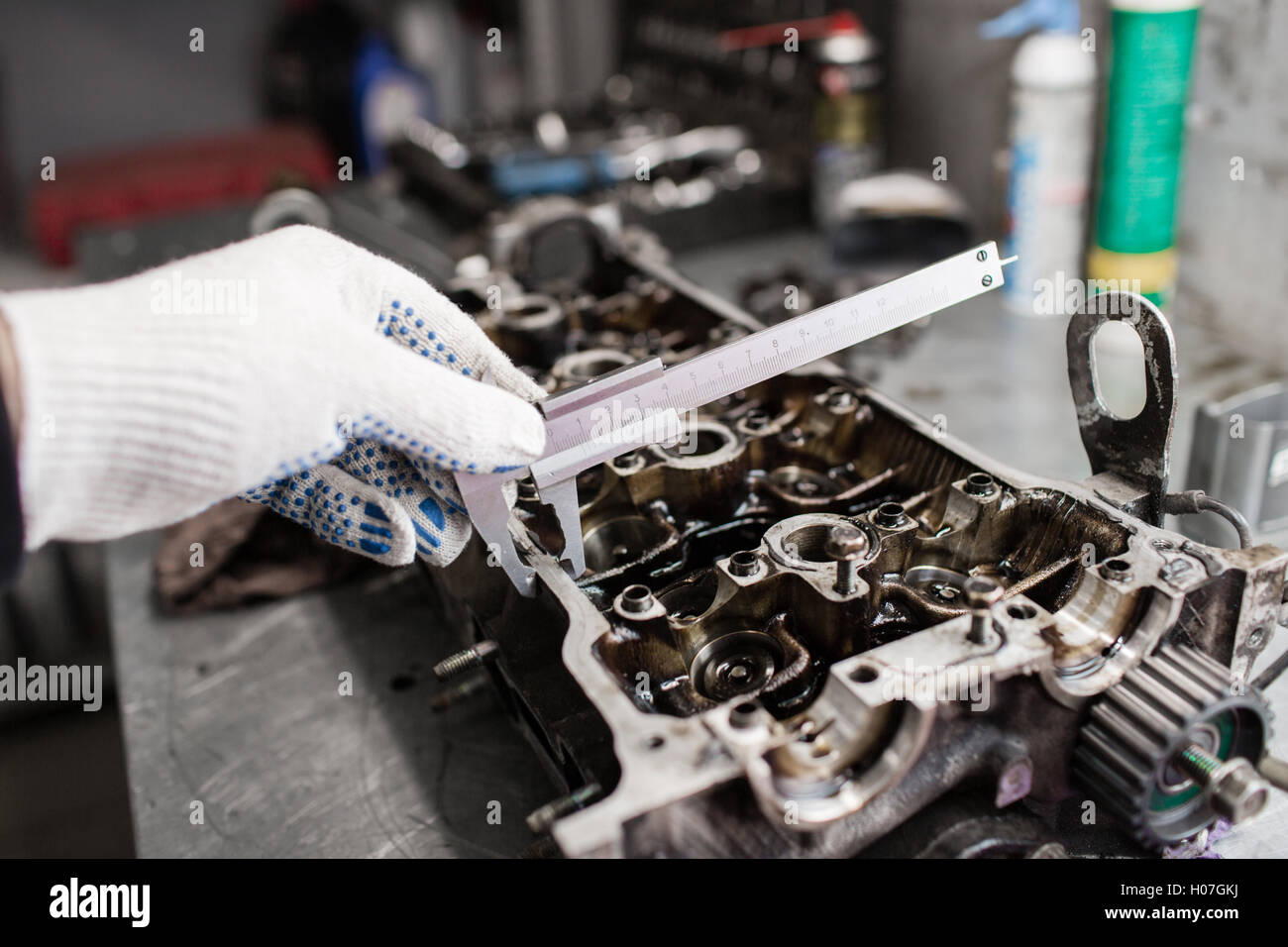 Mechanic, using a calipher, to check the thickness. Full engine major ...