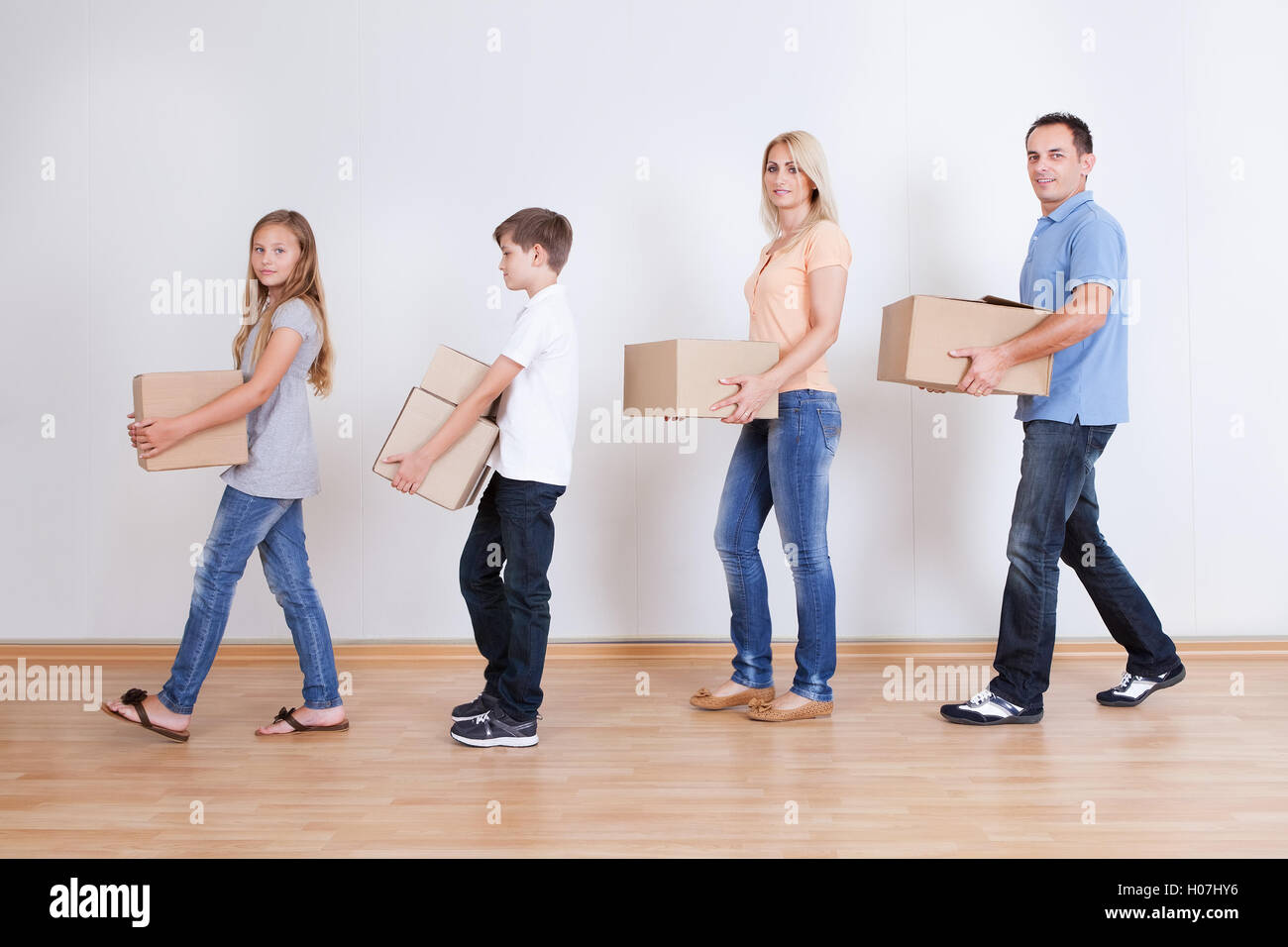 Parents And Two Children With Cardboard Boxes Stock Photo - Alamy