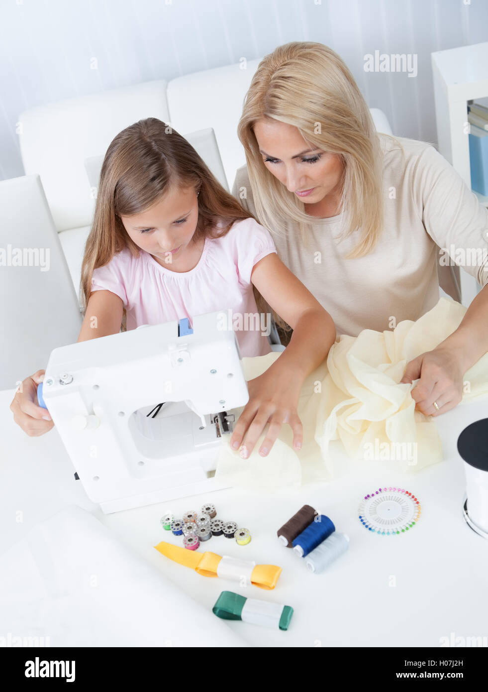 Beautiful Young Girl Sewing With Her Mother Stock Photo - Alamy