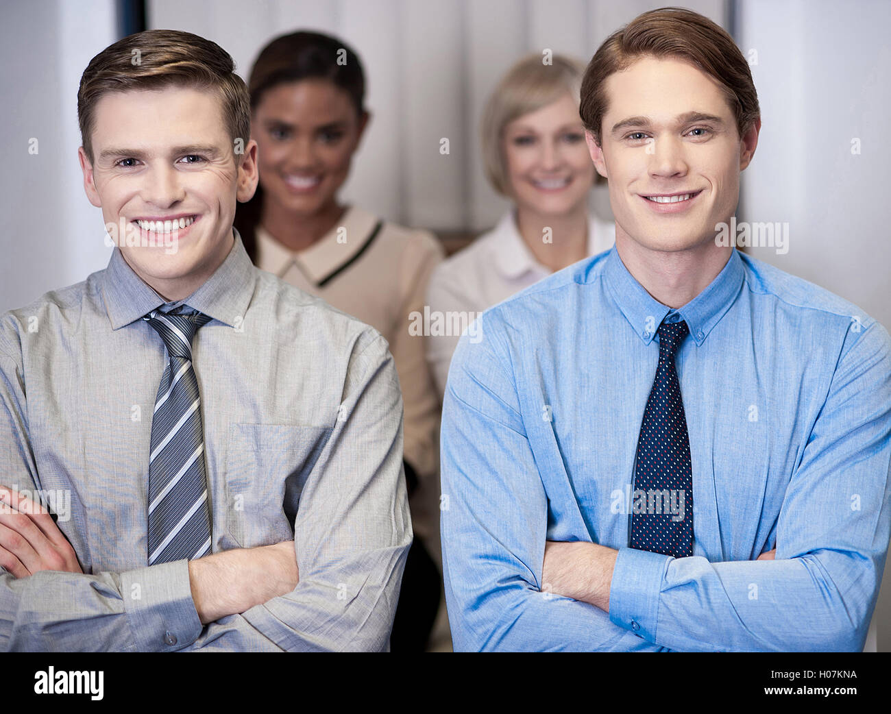 Cheerful work team posing, arms crossed Stock Photo - Alamy