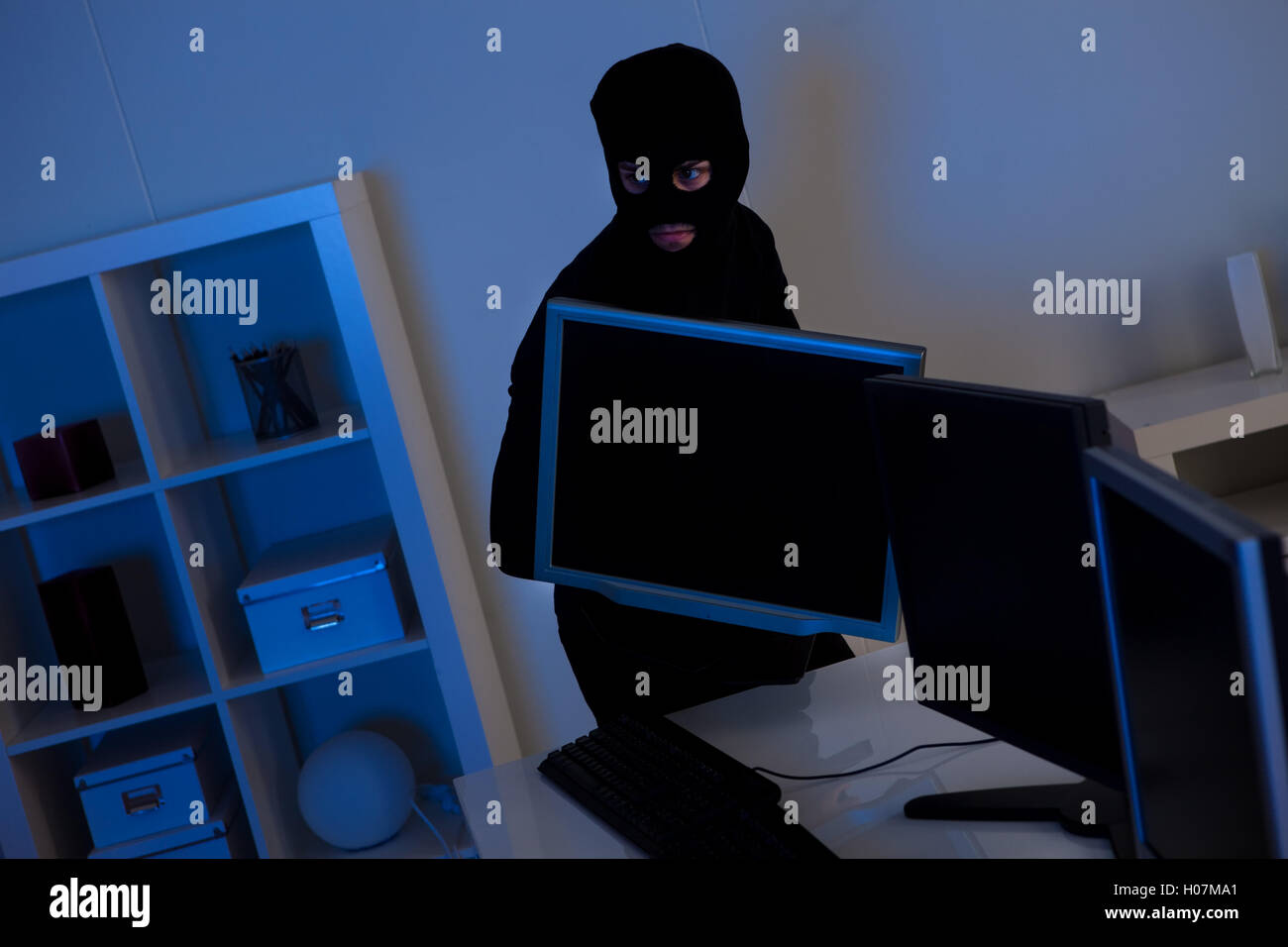 Thief steeling a computer Stock Photo - Alamy