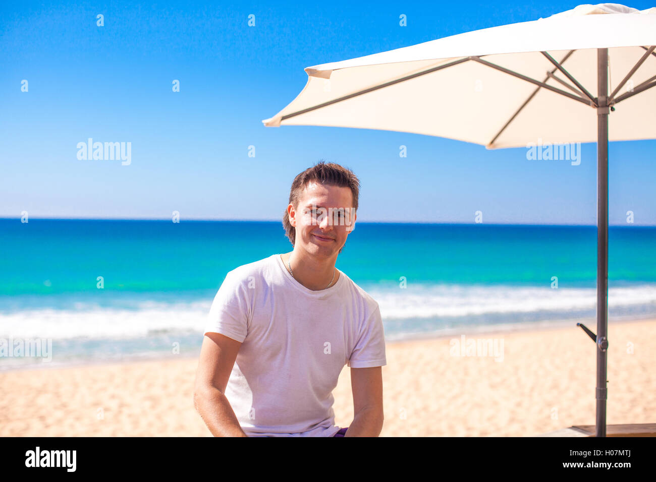 Young man on tropical beach vacation Stock Photo - Alamy