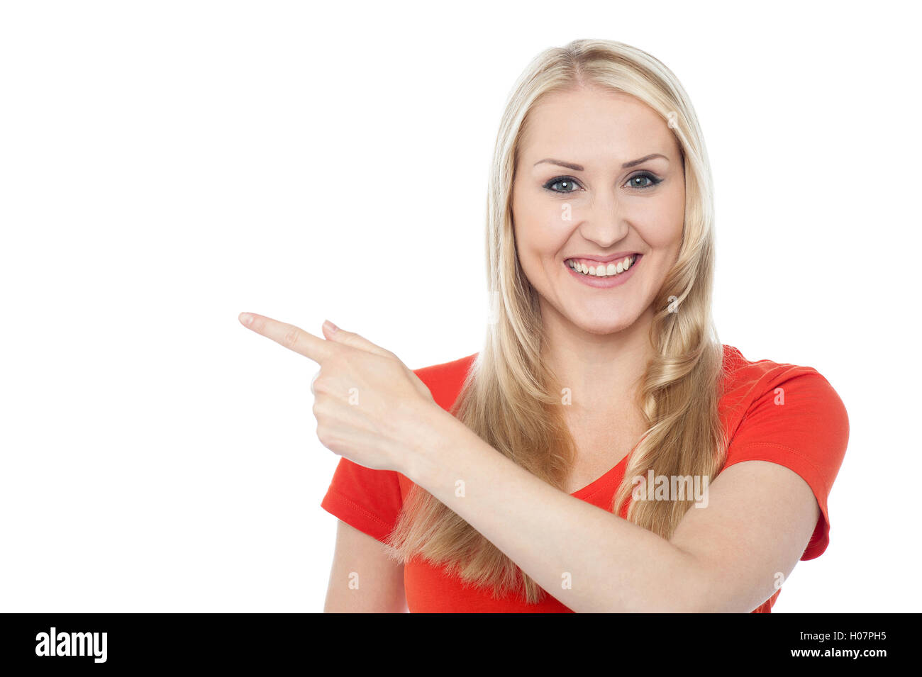 Beautiful smiling woman pointing away Stock Photo - Alamy