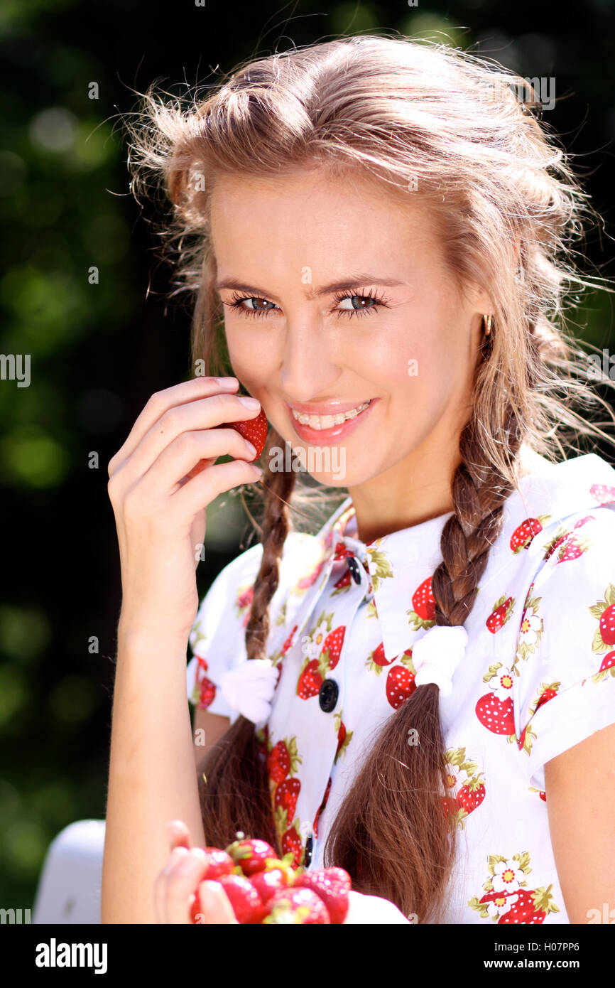 Beautiful girl with a strawberry Stock Photo - Alamy