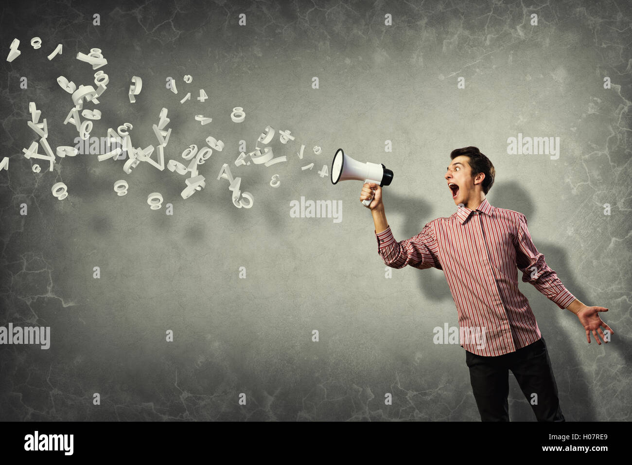 Portrait of a young man shouting using megaphone Stock Photo - Alamy