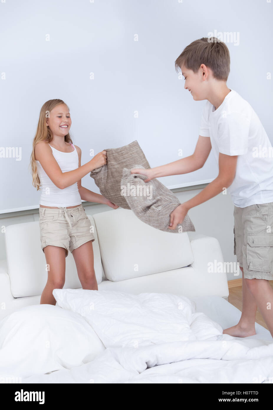 Siblings Having A Pillow Fight Together On Bed Stock Photo - Alamy