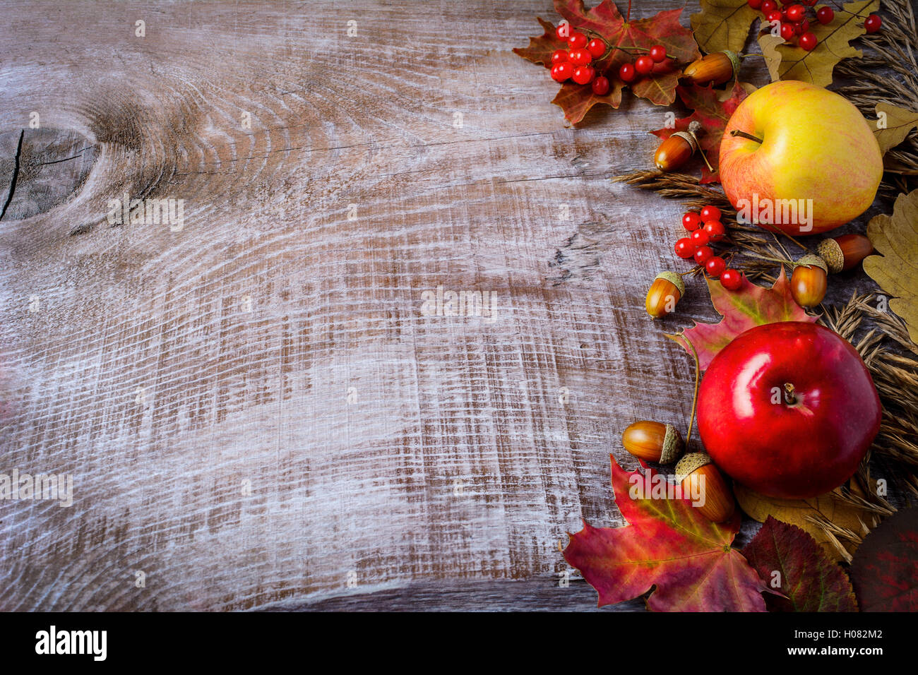 Border of apples, berries and fall leaves on the rustic wooden ...