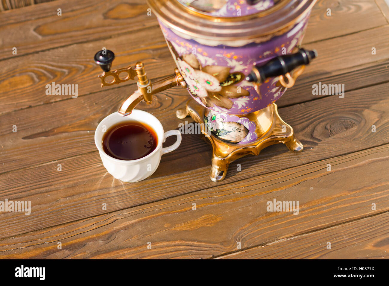 Vintage Russian samovar with a great cup of tea on a wooden background ...