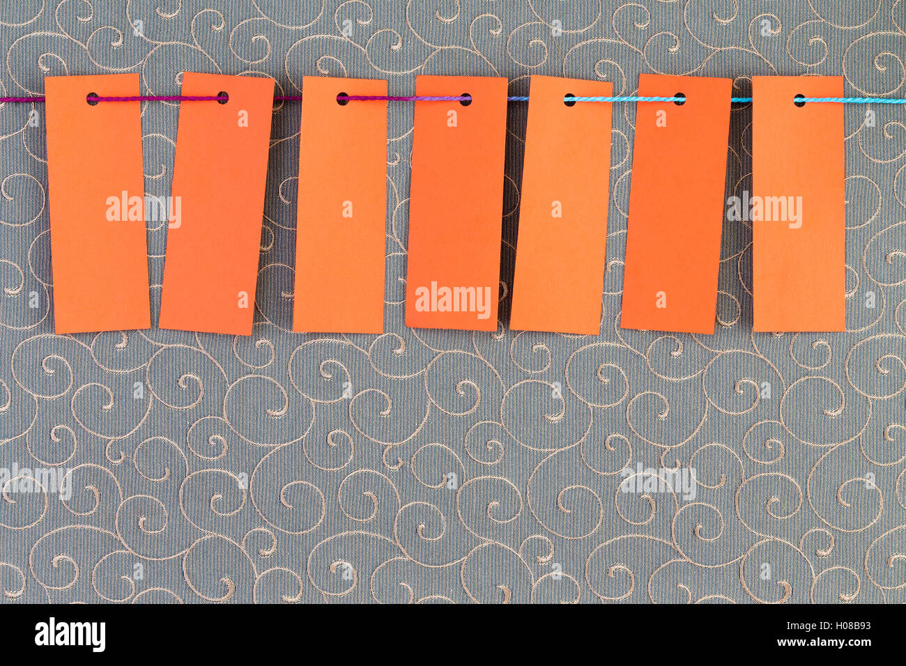 Seven strung together orange rectangular tags with copy space over ...