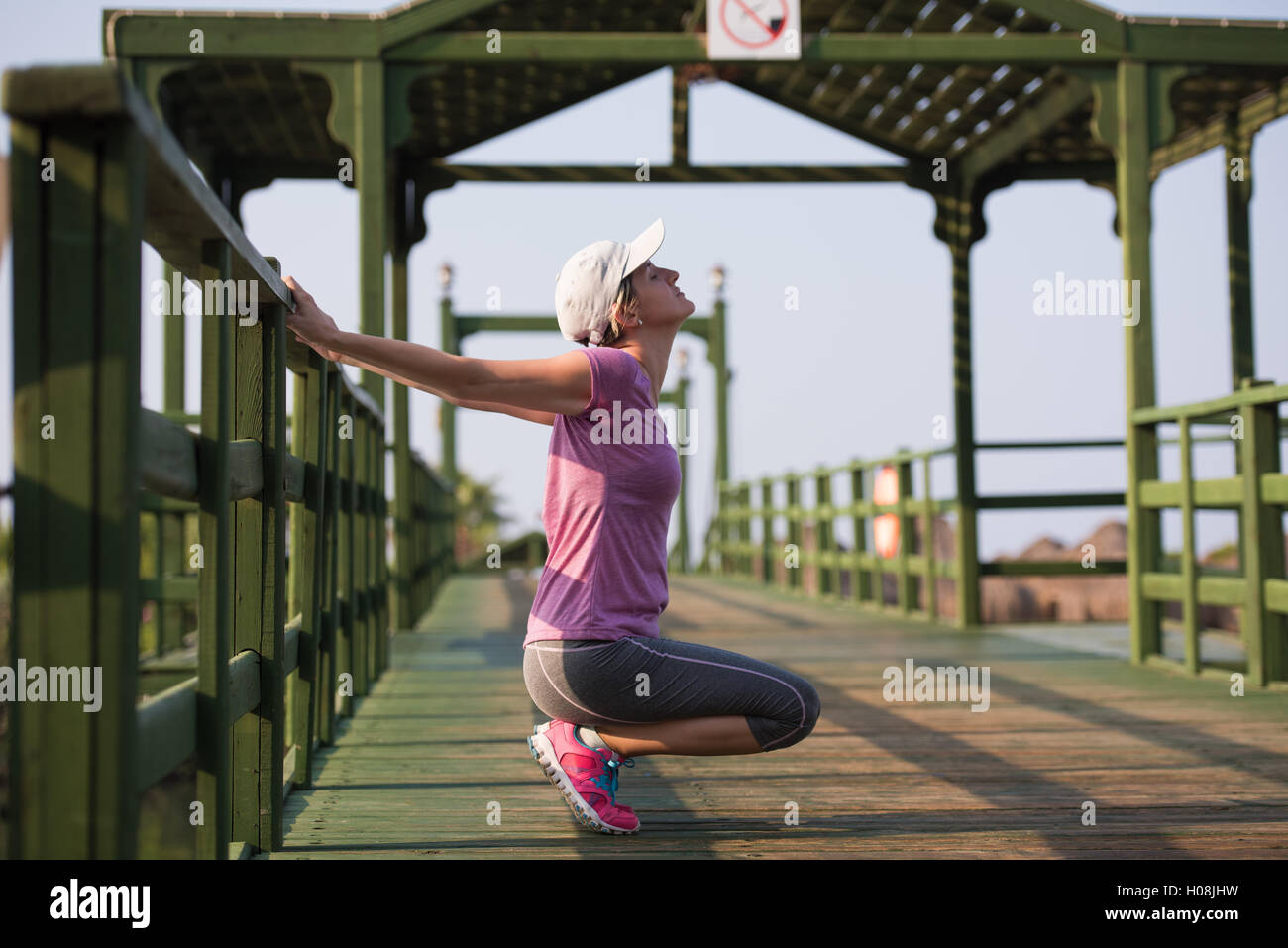 runner woman warming up and stretching before morning jogging Stock ...