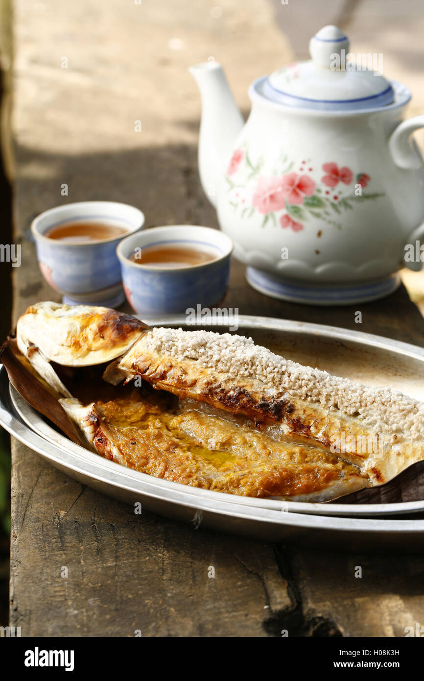 Fried carp fish on iron plate with tea cup on the table Stock Photo - Alamy