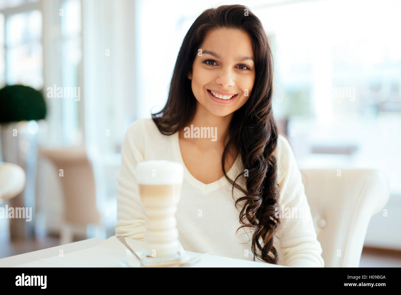 Beautiful woman drinking coffee in cafe Stock Photo - Alamy
