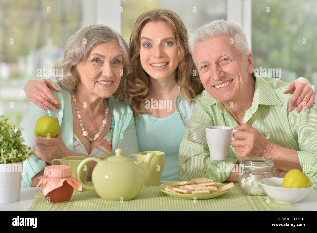 daughter with senior parents drinking tea Stock Photo - Alamy