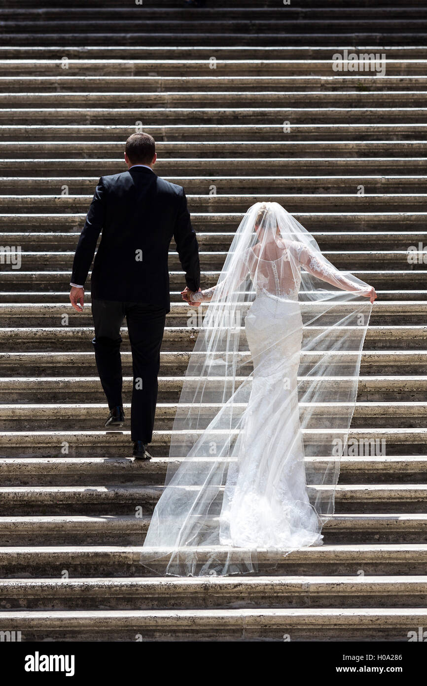 Bride and groom walking up stair Stock Photo - Alamy