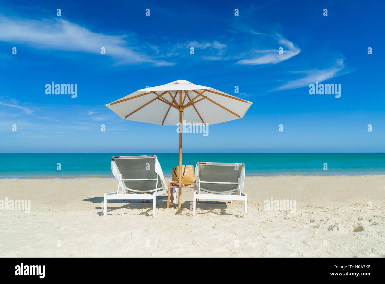 Beach chairs on the white sand beach with cloudy blue sky Stock Photo ...