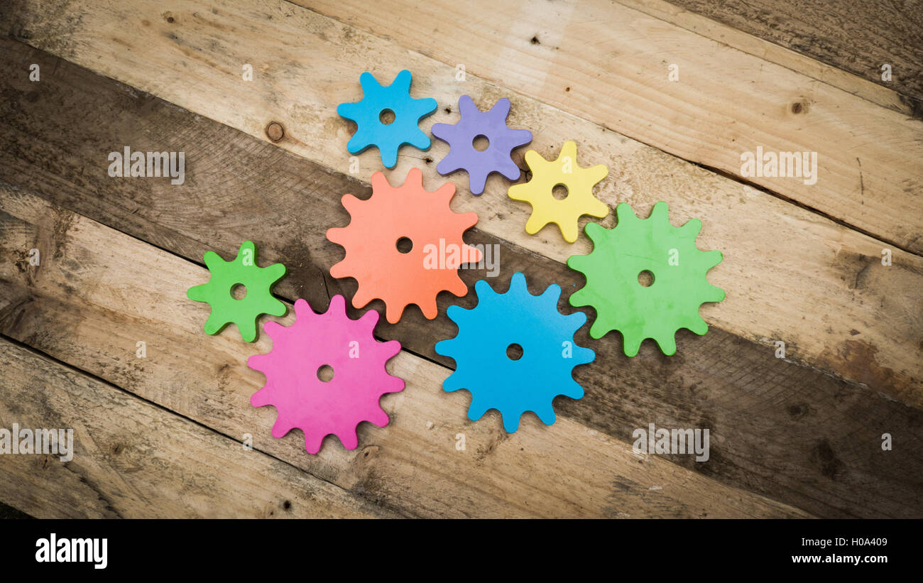 Coloured gear cogs on a reclaimed wood boards Stock Photo - Alamy
