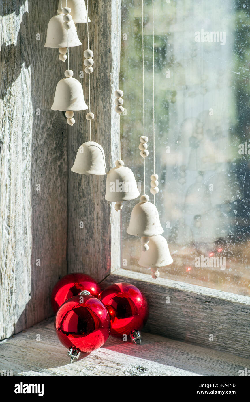 Christmas bells hanging in front of an old window Stock Photo - Alamy