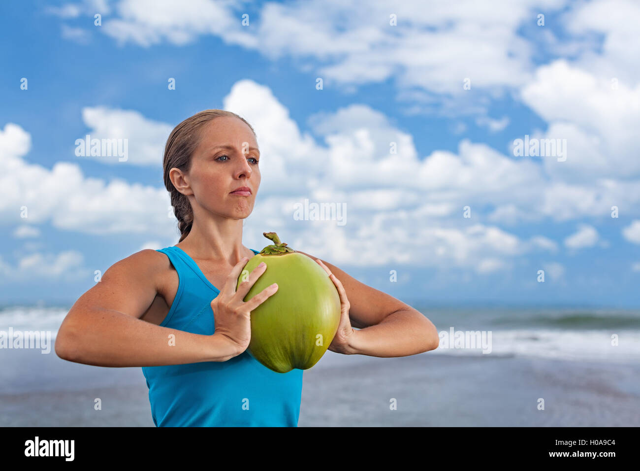 Woman fitness exercise with raw coconut as weight to keep fit and ...