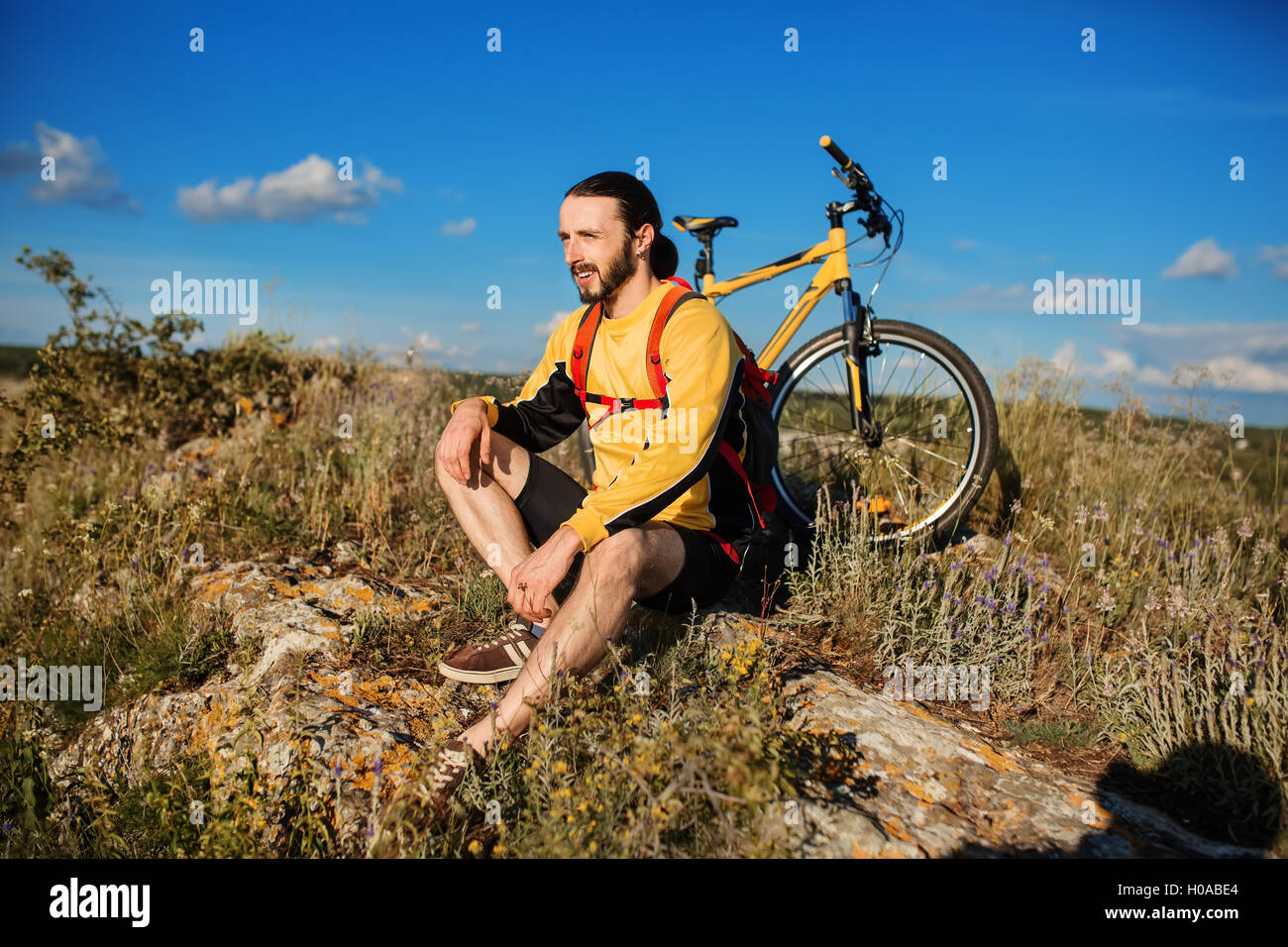 Man sitting under sun light at day near his bicycle outdoor Stock Photo ...