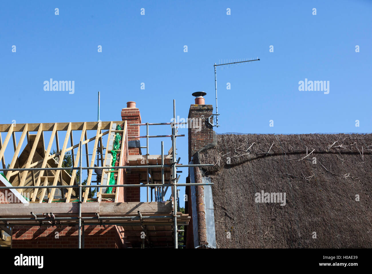 A half built house, roof open to the weather with scaffolding and ...