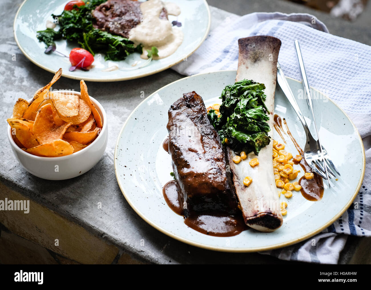 Roasted mutton ribs with fried potato and salad on table Stock Photo ...