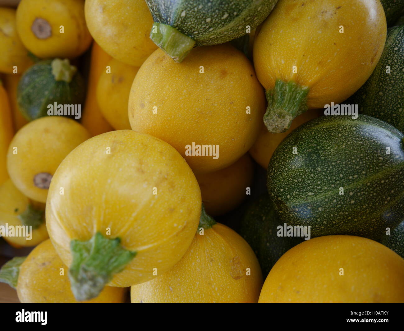 Close up of fresh, yellow and green baby courgettes on sale on market ...