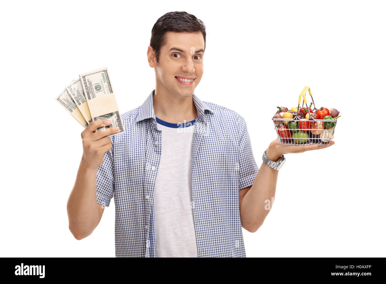 Smiling guy holding stacks of money and a small shopping basket ...