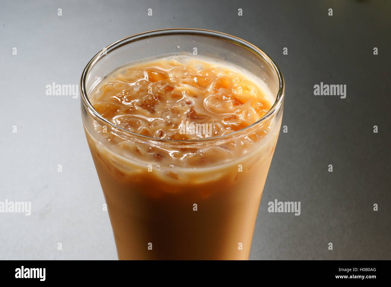 Glass of milky coffee with ice in asia on grey background Stock Photo ...
