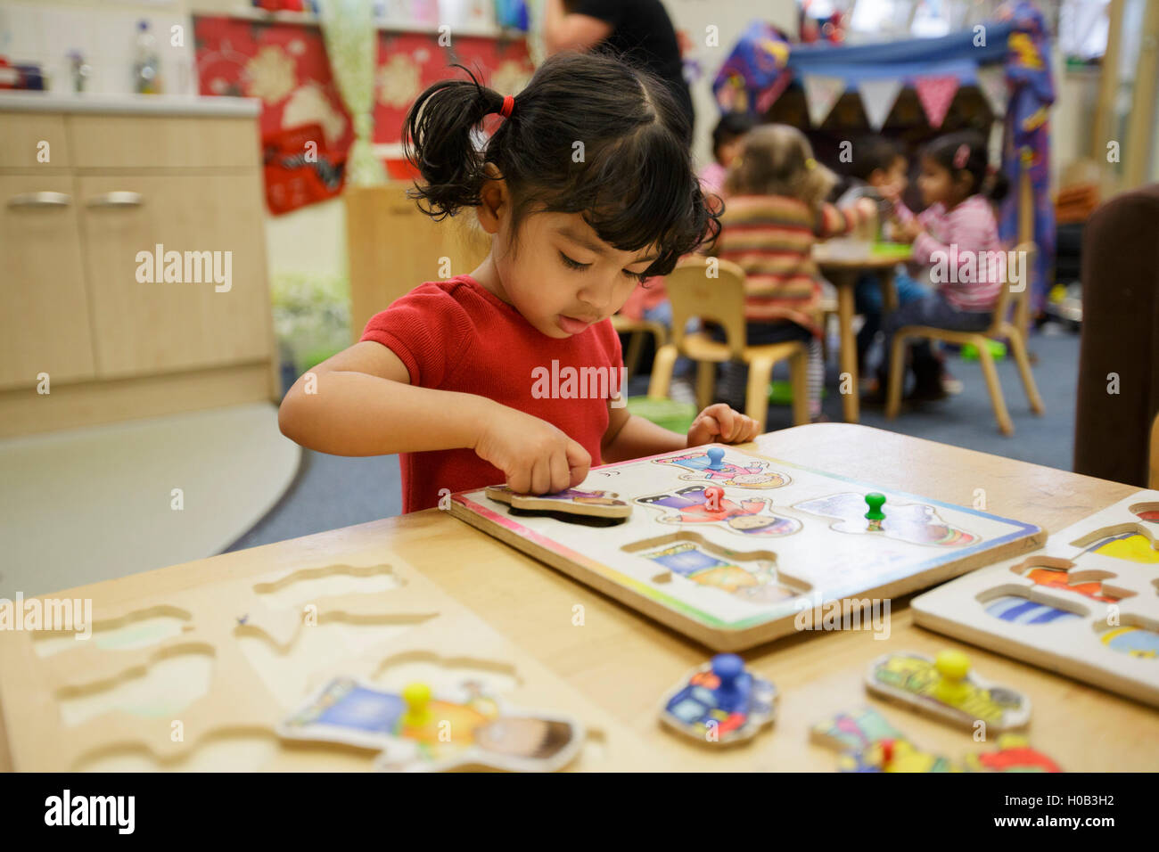 A girl playing with a jigsaw at the Sure Start Palfrey Nursery in ...