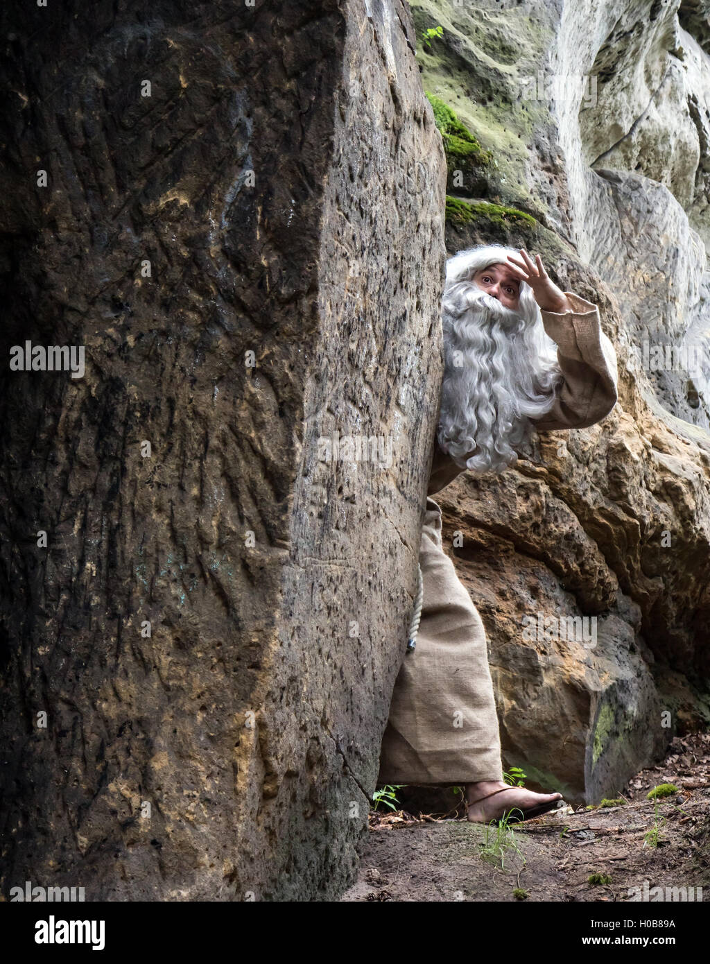 Old hermit peeks behind rock. The bearded monk in nature Stock Photo ...