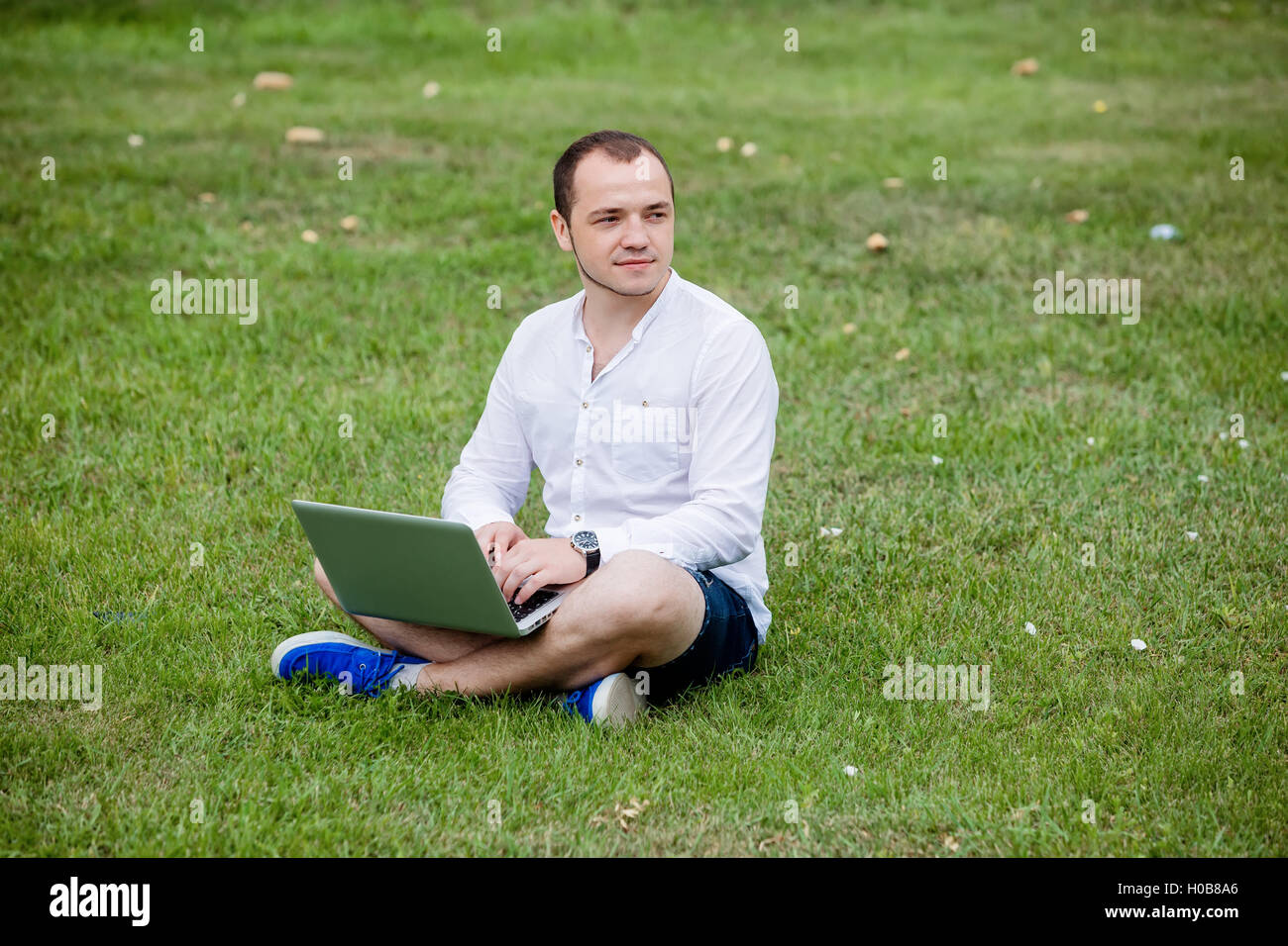 A young man with laptop working outdoor Stock Photo - Alamy