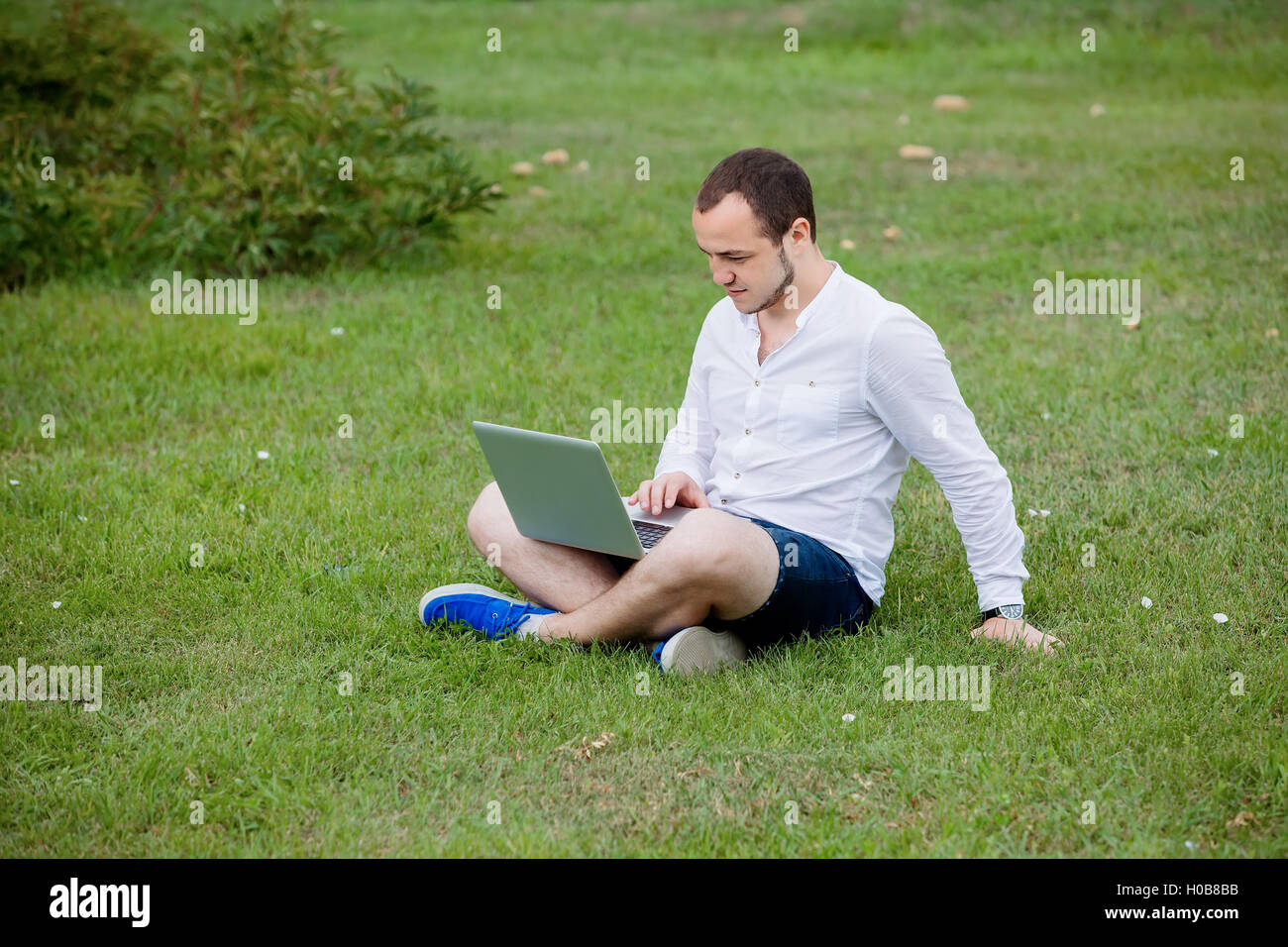 A young man with laptop working outdoor Stock Photo - Alamy
