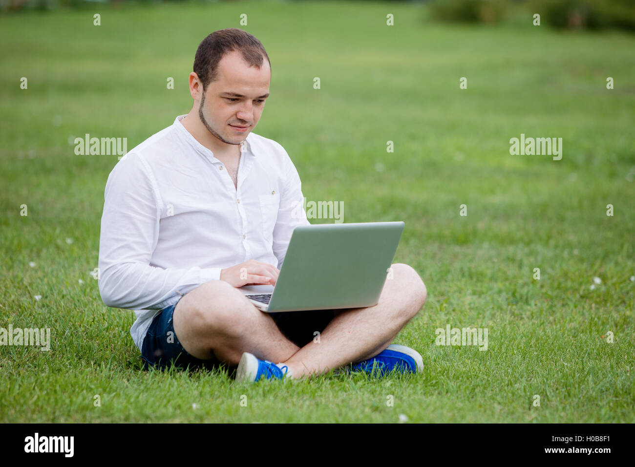 A young man with laptop working outdoor Stock Photo - Alamy