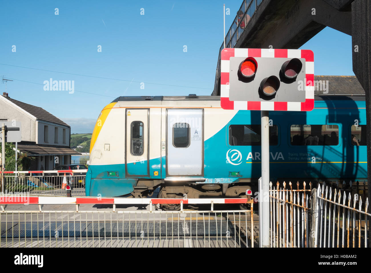 Arriva train passing barrier of a level crossing at Ferryside village ...
