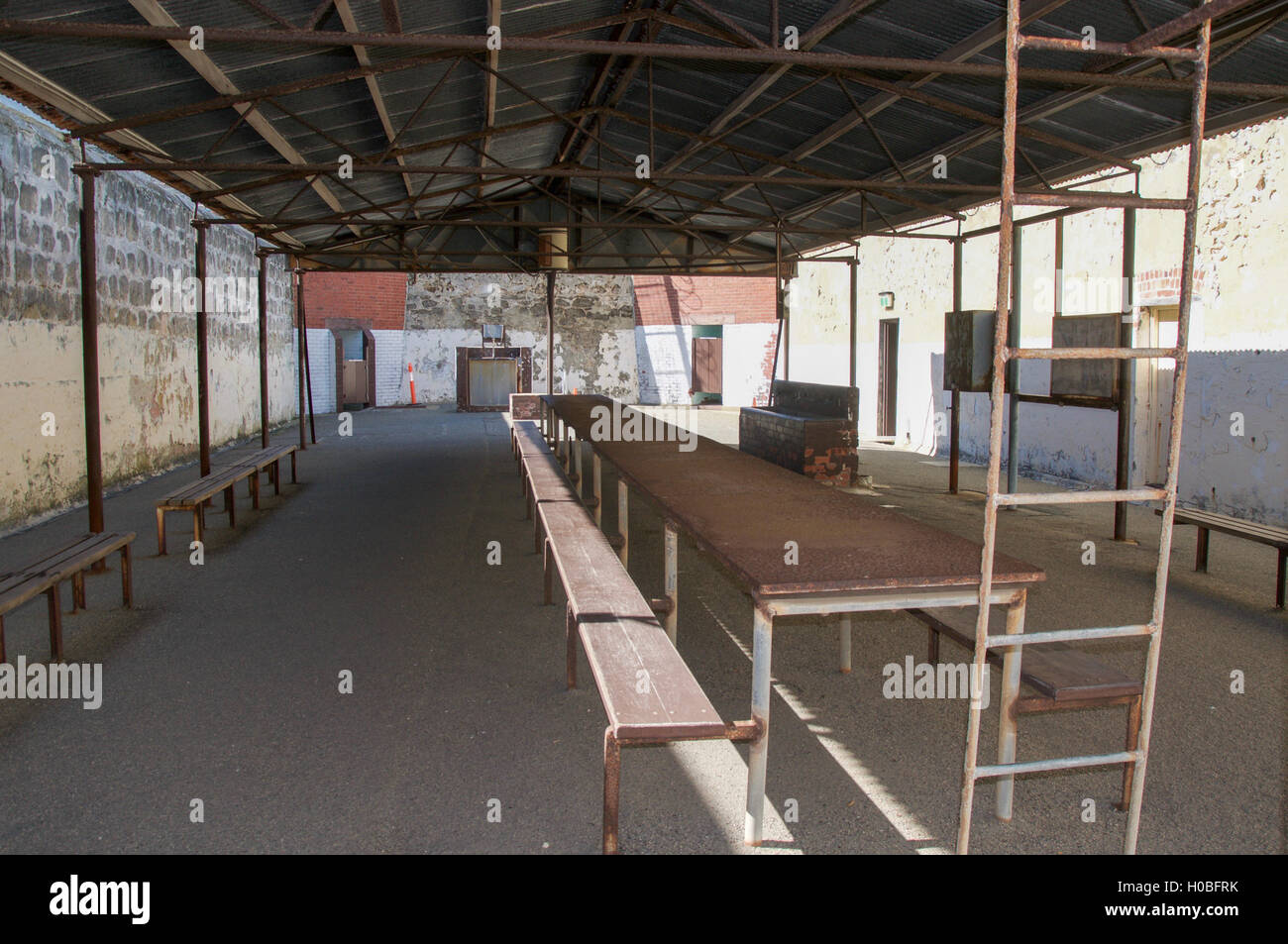 Outdoor rusted metal picnic tables and ladder with covered shelter in ...