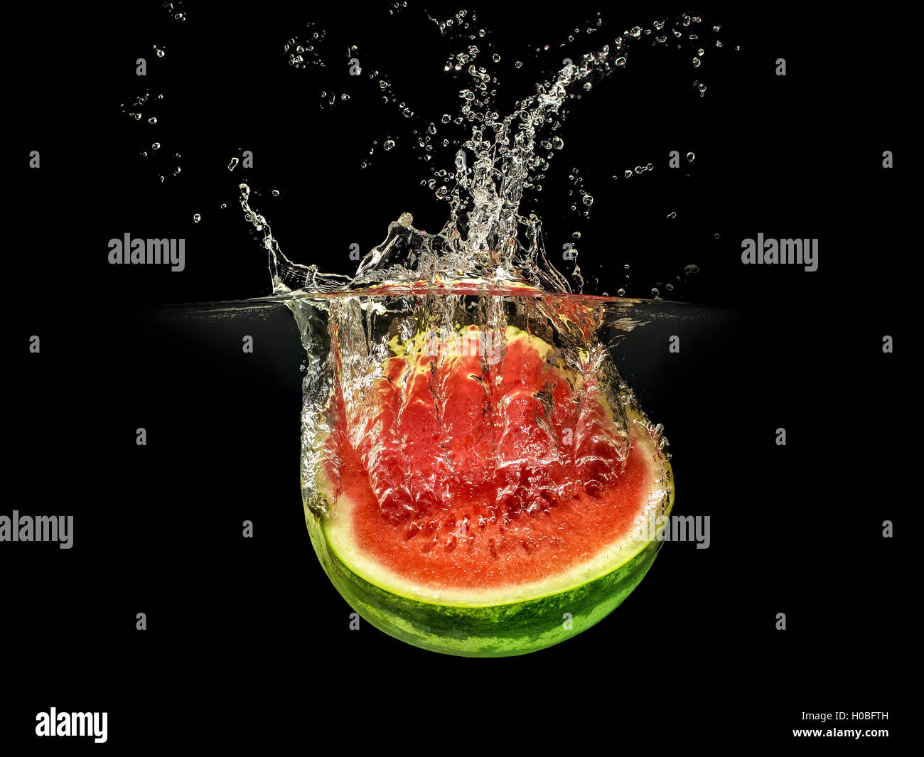 Fresh melon falling in water with splash on black Stock Photo - Alamy