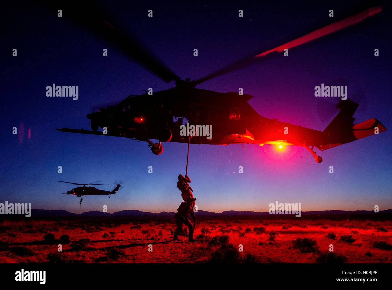 U.S. Air Force soldiers climb into helicopters at sunset during ...