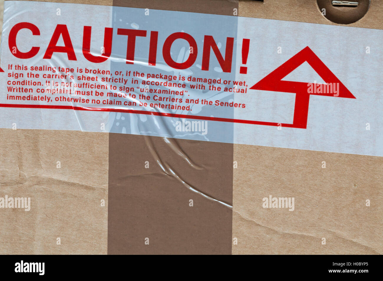 Caution notice on sealing tape on parcel Stock Photo - Alamy