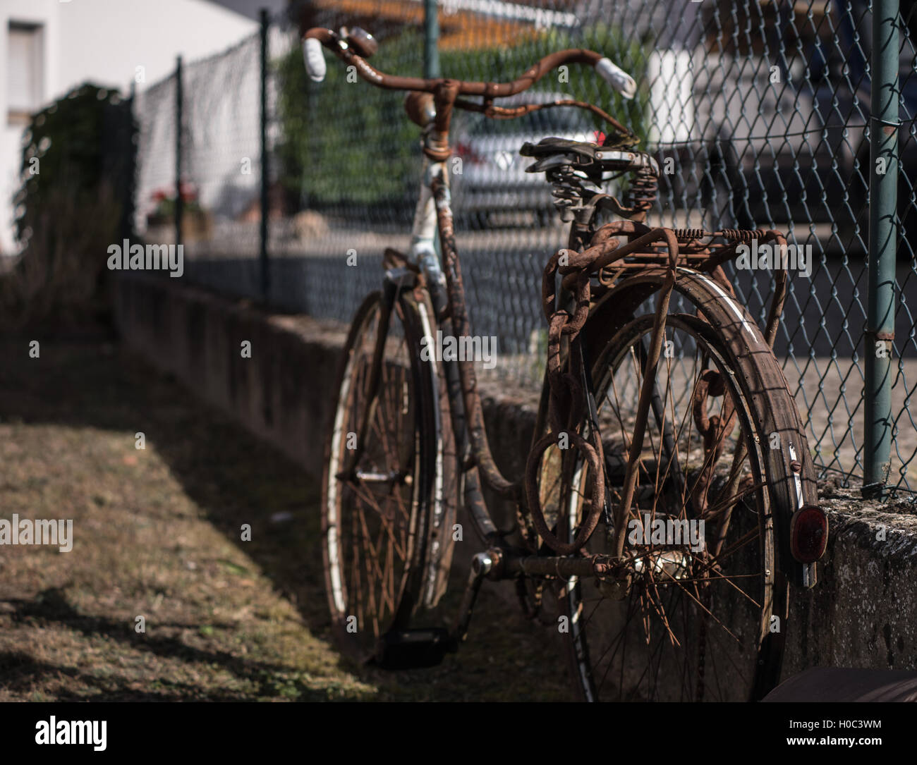 Rusty old bicycle leaning on fence Stock Photo - Alamy