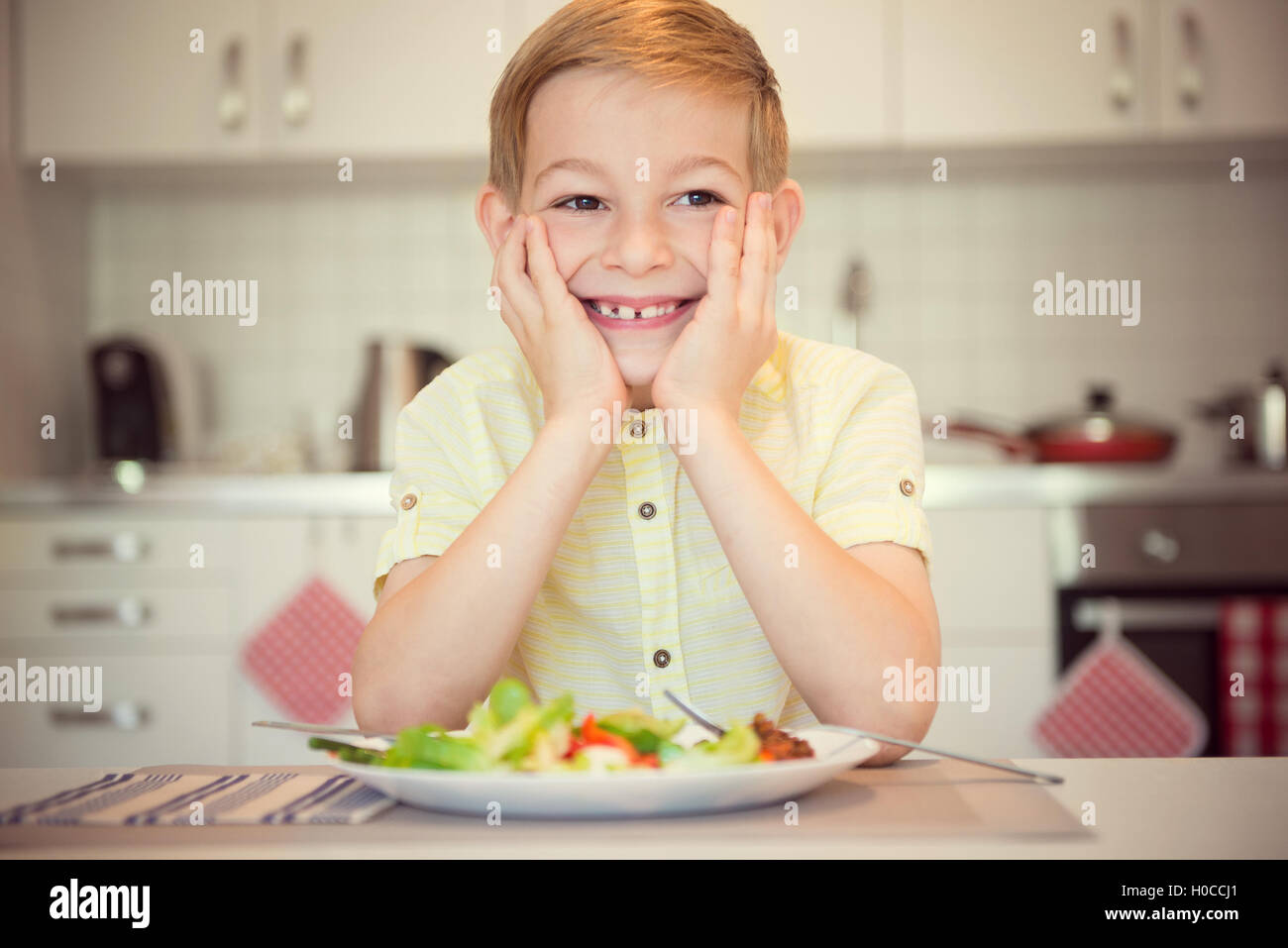 Young diligent happy boy at a table eating healthy meal Stock Photo - Alamy