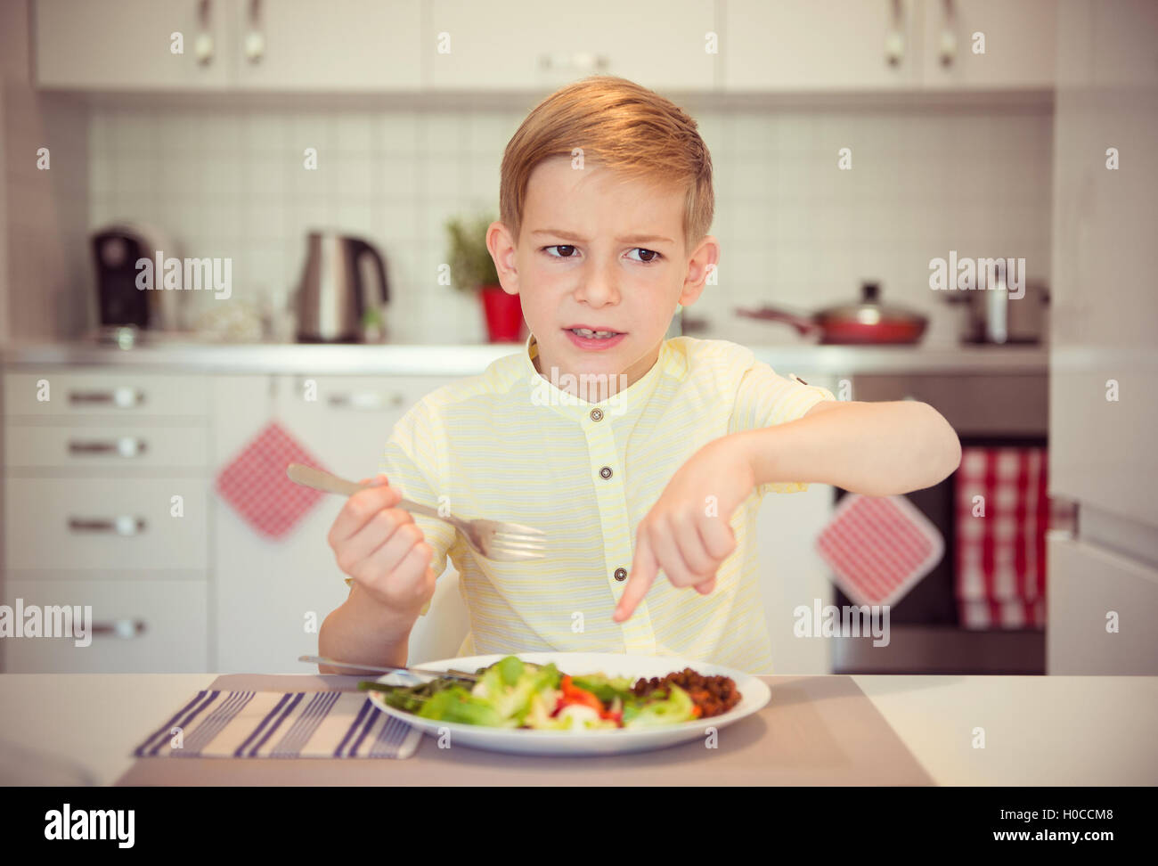 Angry hungry boy child complains about the food on the table Stock ...