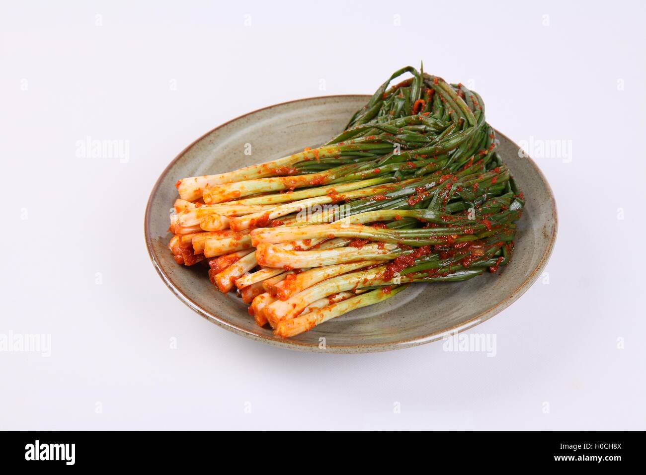 Korean green onion kimchi on plate on white background Stock Photo - Alamy