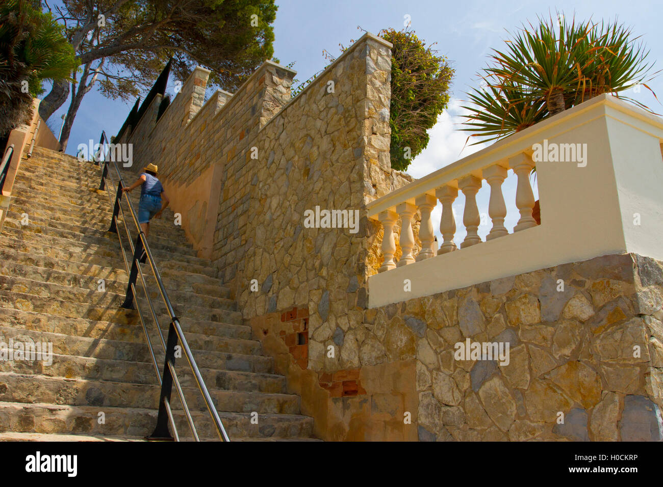 A holidaymaker walking up steps in Port de Mar, Majorca Stock Photo - Alamy