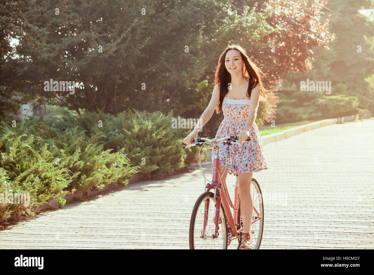 The young girl with bicycle in park Stock Photo - Alamy