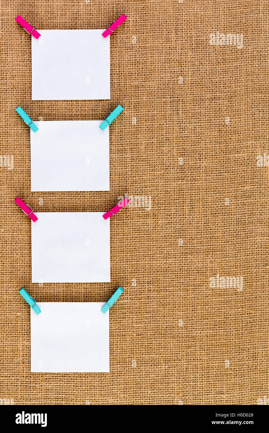 Side border of neatly hanging blank white square notepads on colorful ...