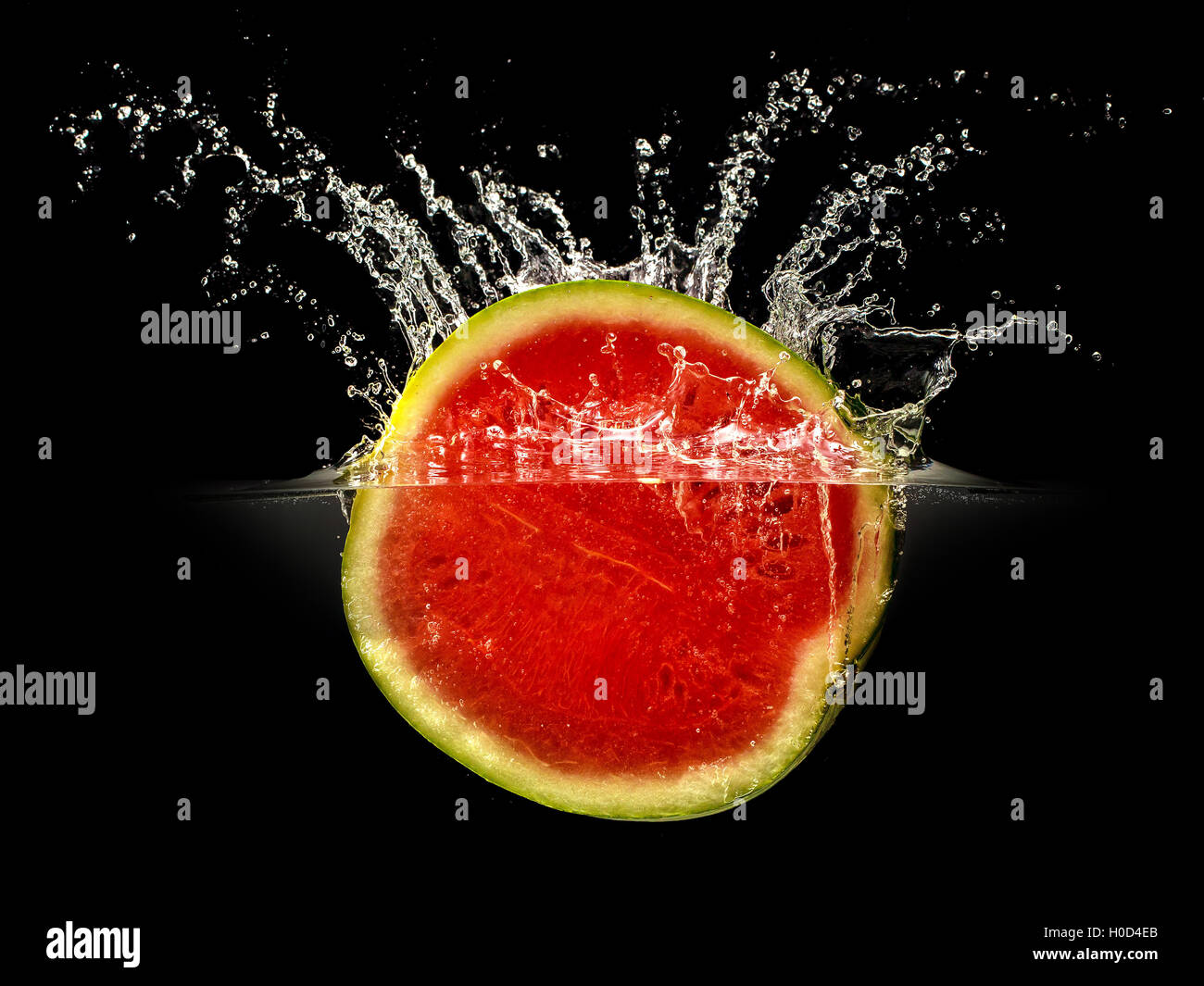 Fresh melon falling in water with splash on black Stock Photo - Alamy