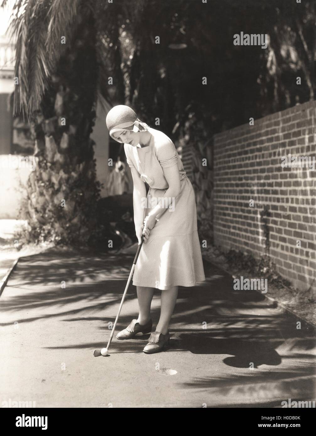 Woman playing miniature golf Stock Photo - Alamy