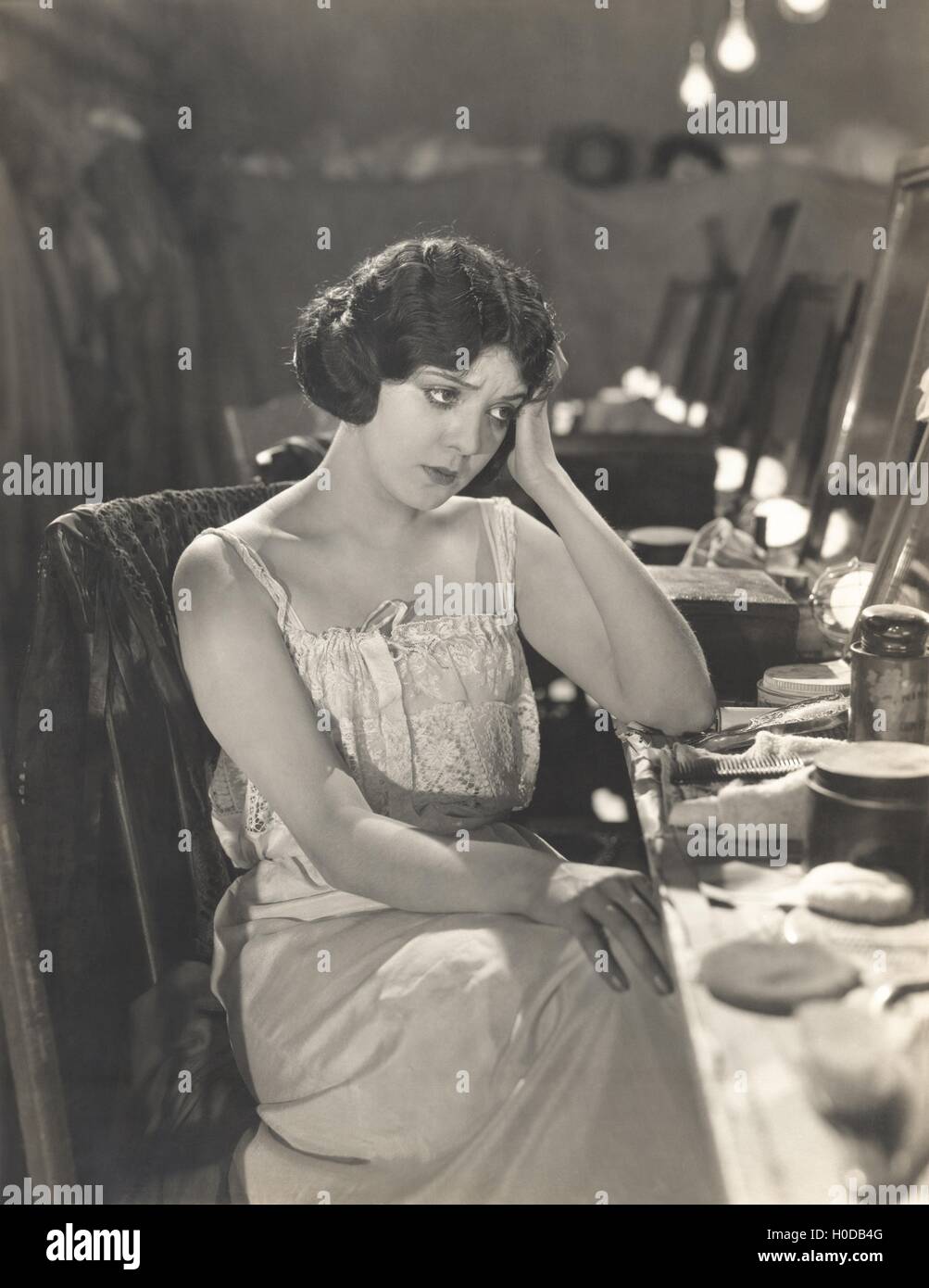 Sad woman sitting in dressing room Stock Photo - Alamy